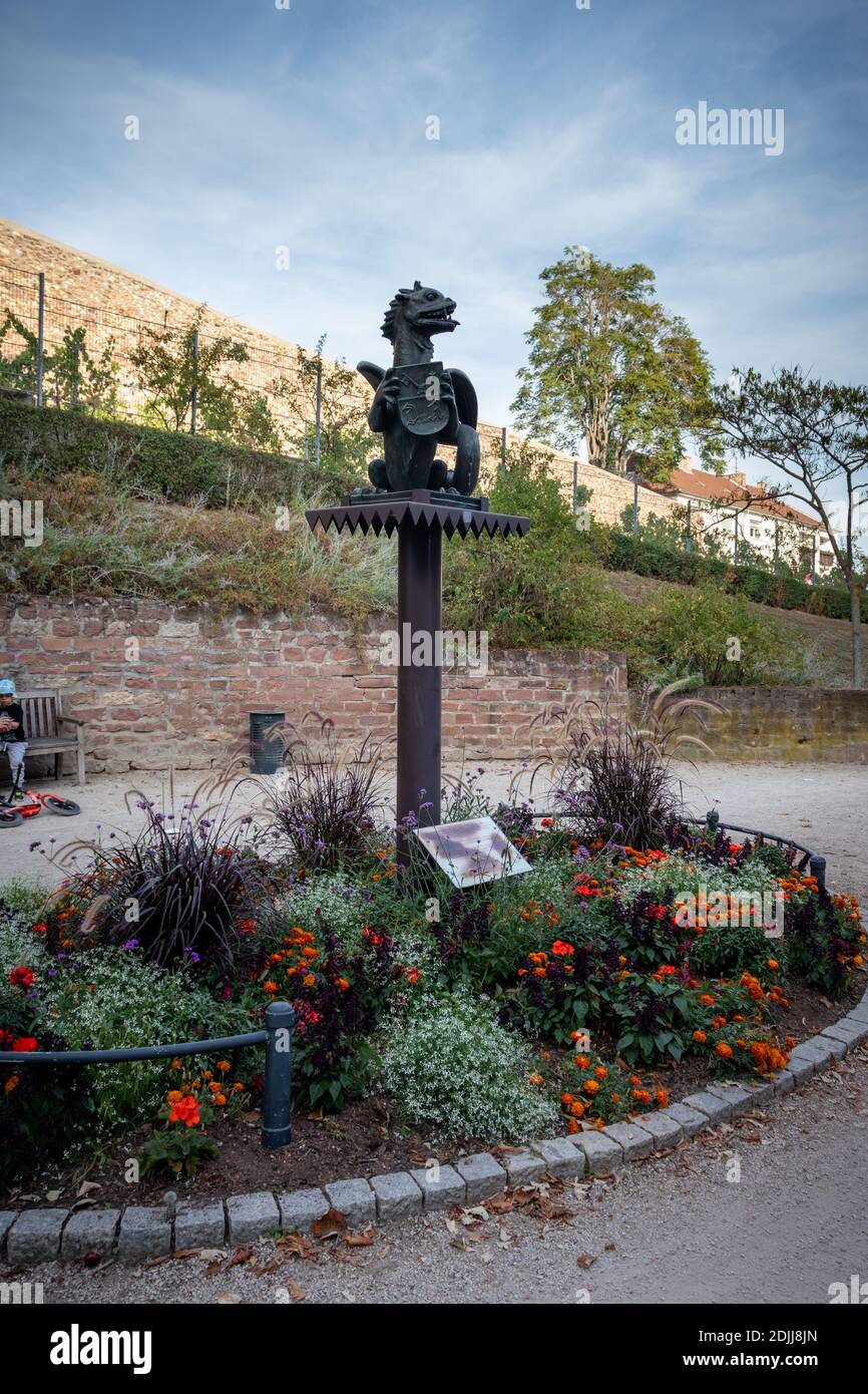 Dragon statue in a flower garden in Worms, Germany on a summer day ...
