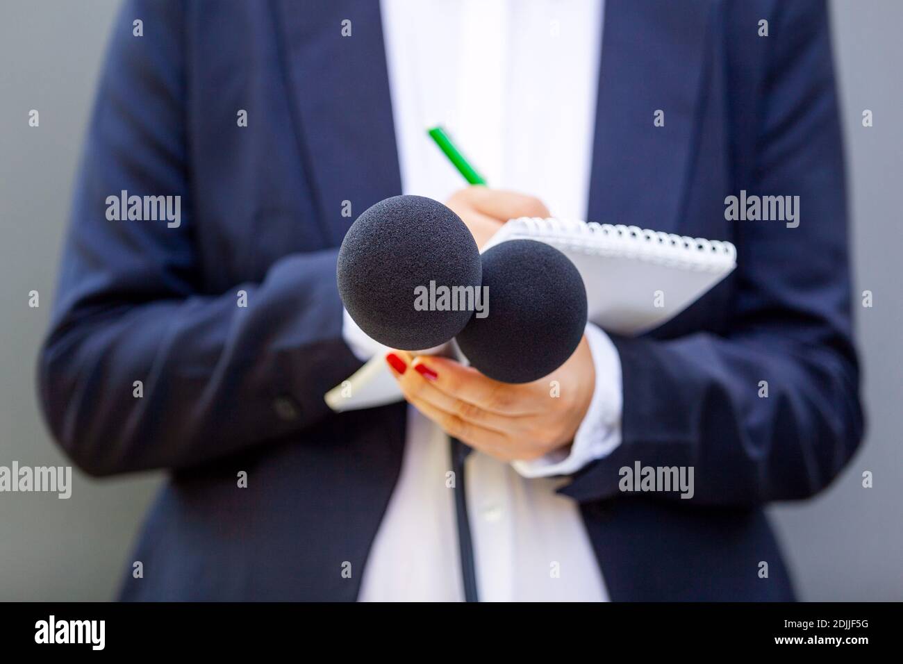 Female journalist at news conference or media event, writing notes ...