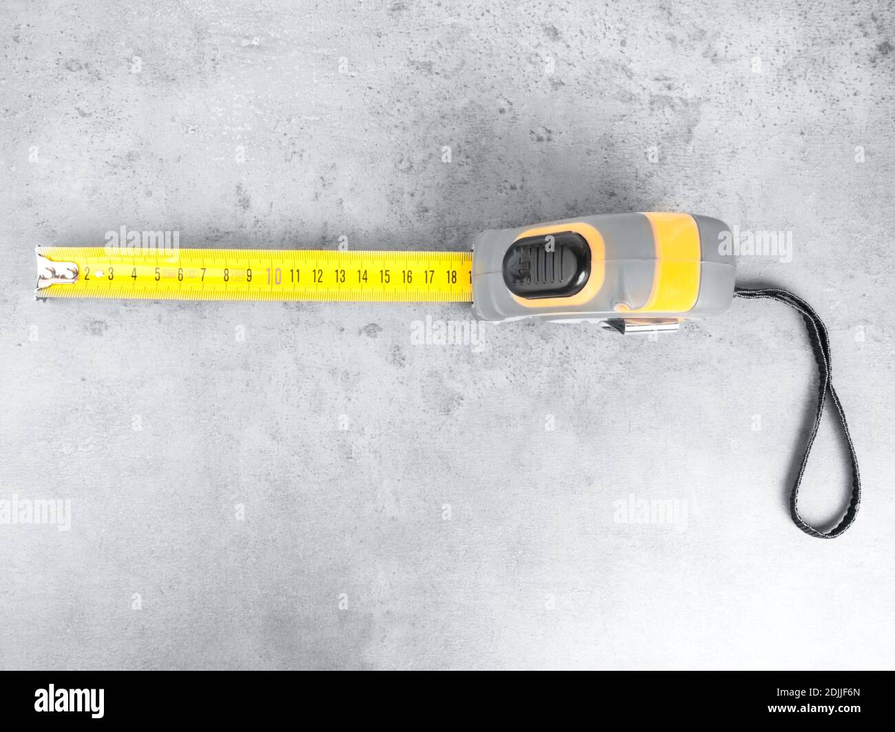 yellow tape measure on a ultimate grey concrete background, numerical ...