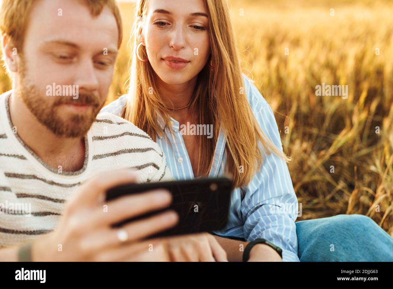 Loving couple using mobile phone hi-res stock photography and images ...