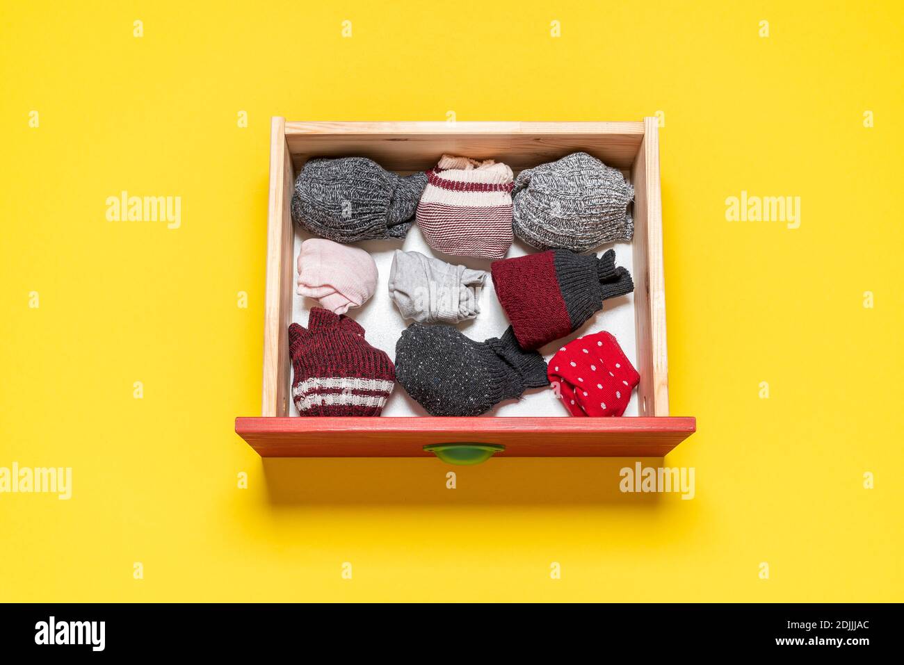 Top view with wooden drawer with socks on a yellow background. Variety ...