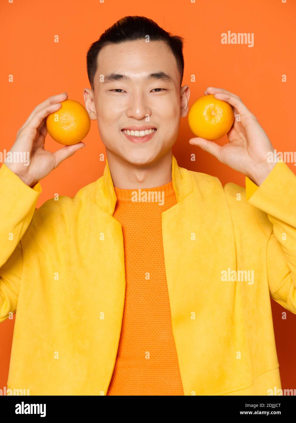 Cheerful man with oranges in his hands on an isolated background and a ...