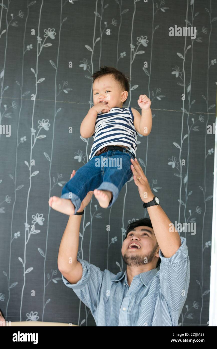 Man Carrying Baby Boy Against Wall Stock Photo - Alamy