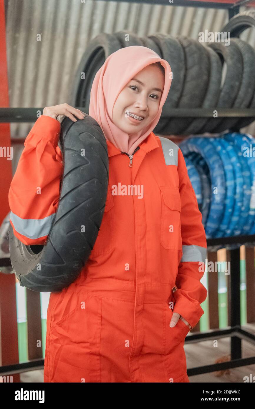 veiled female mechanic wears a wearpack uniform when carrying a ...