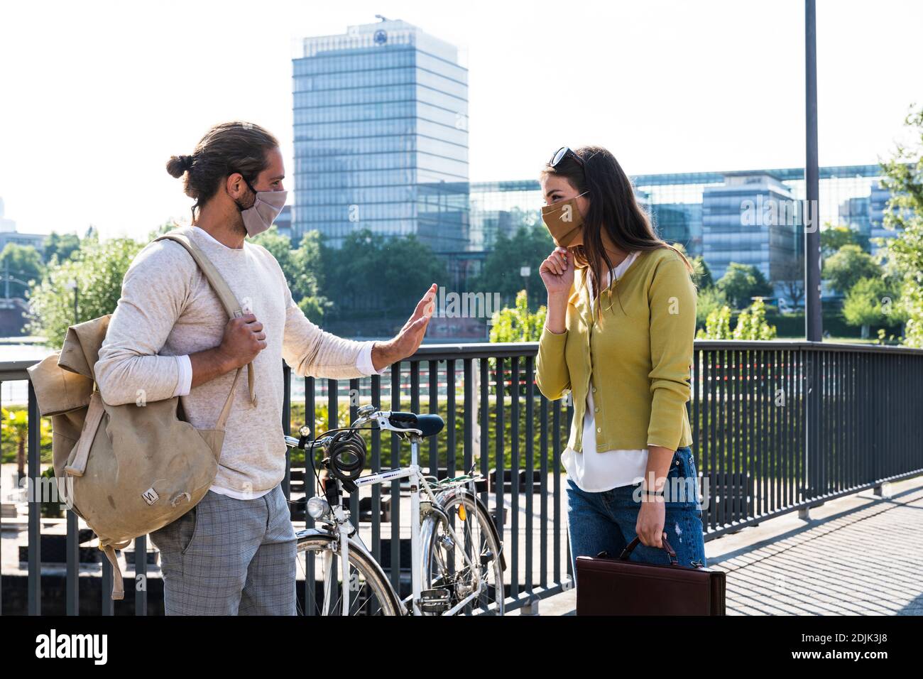 young couple with face mask out and about in the city, gesture, keep ...