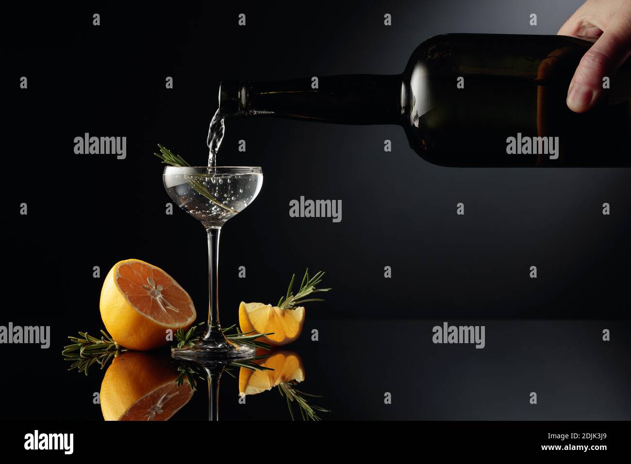 Gin is poured in a small glass from an antique bottle of dark glass. A ...