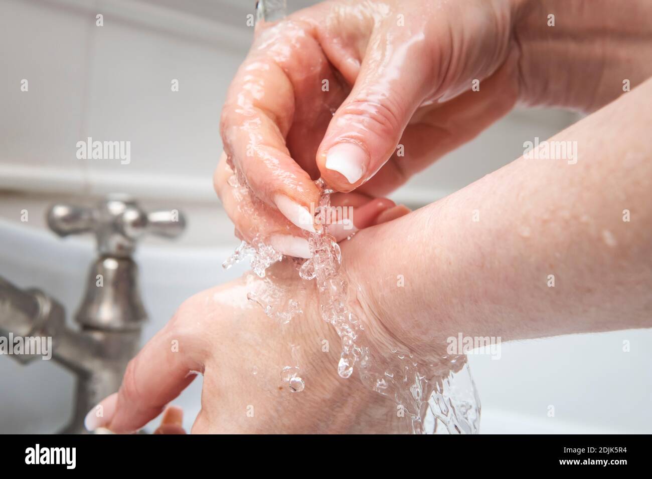 Woman washing hands under running water Stock Photo - Alamy