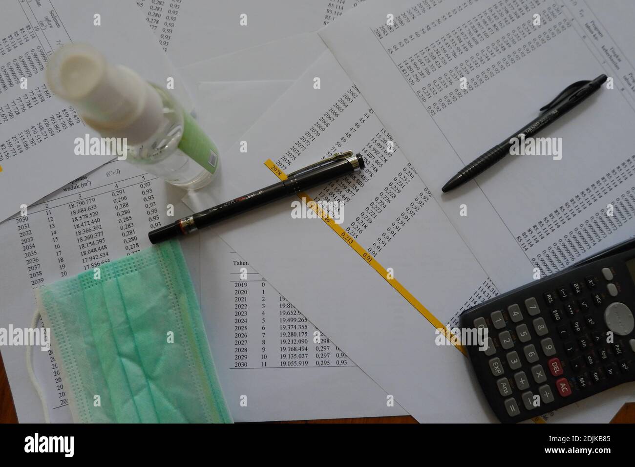 A top view shot of the medical mask, calculator, antiseptic, and a pen ...