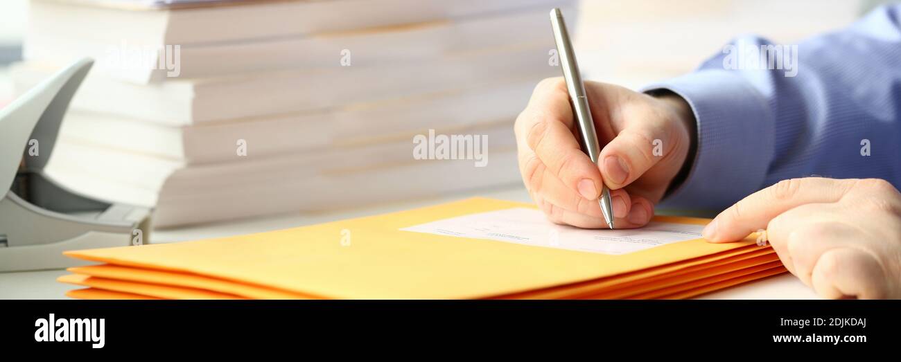 Male hand is signing envelope in office Stock Photo - Alamy