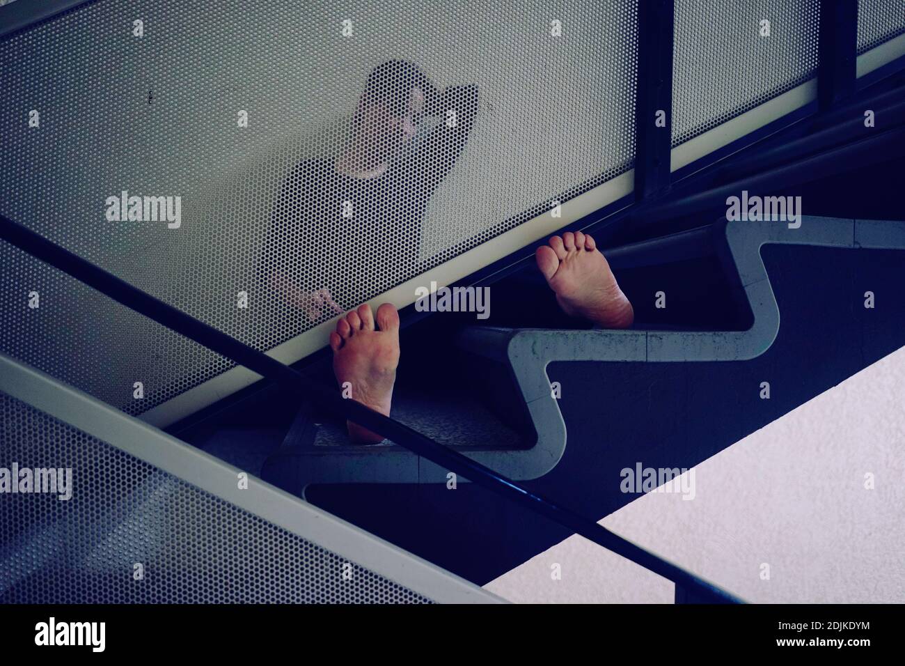 Man Sen Through Railing Sitting On Staircase Stock Photo - Alamy