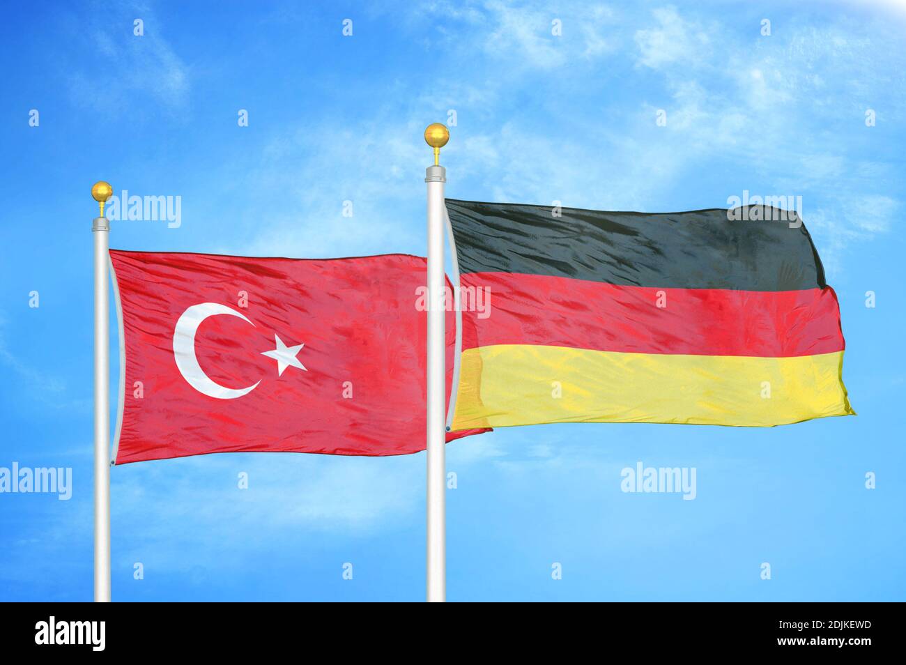 Turkey and Germany two flags on flagpoles and blue cloudy sky Stock ...