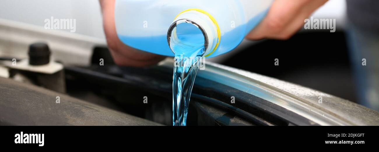 Young man pouring motor oil into car engine Stock Photo - Alamy