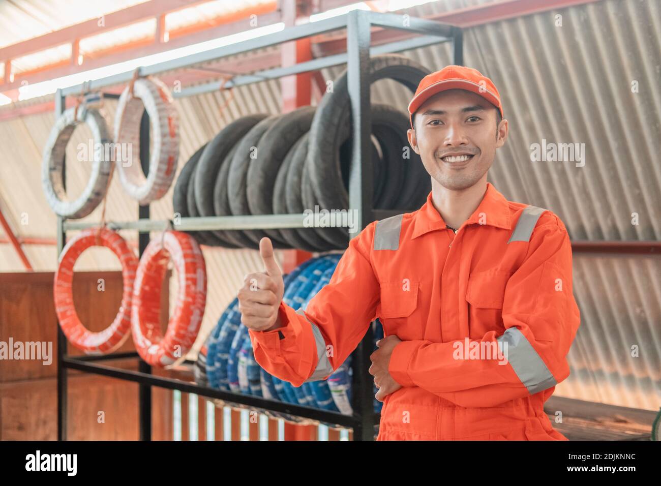 mechanic in red wearpack with thumbs up while in the workshop with a ...