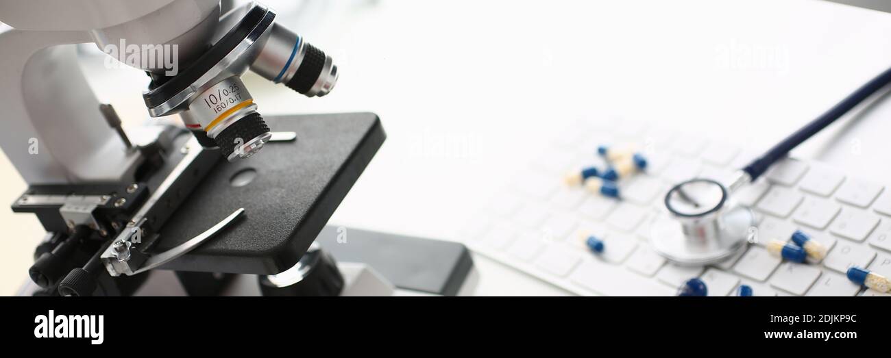 Microscope, stethoscope and pills on white keyboard Stock Photo - Alamy