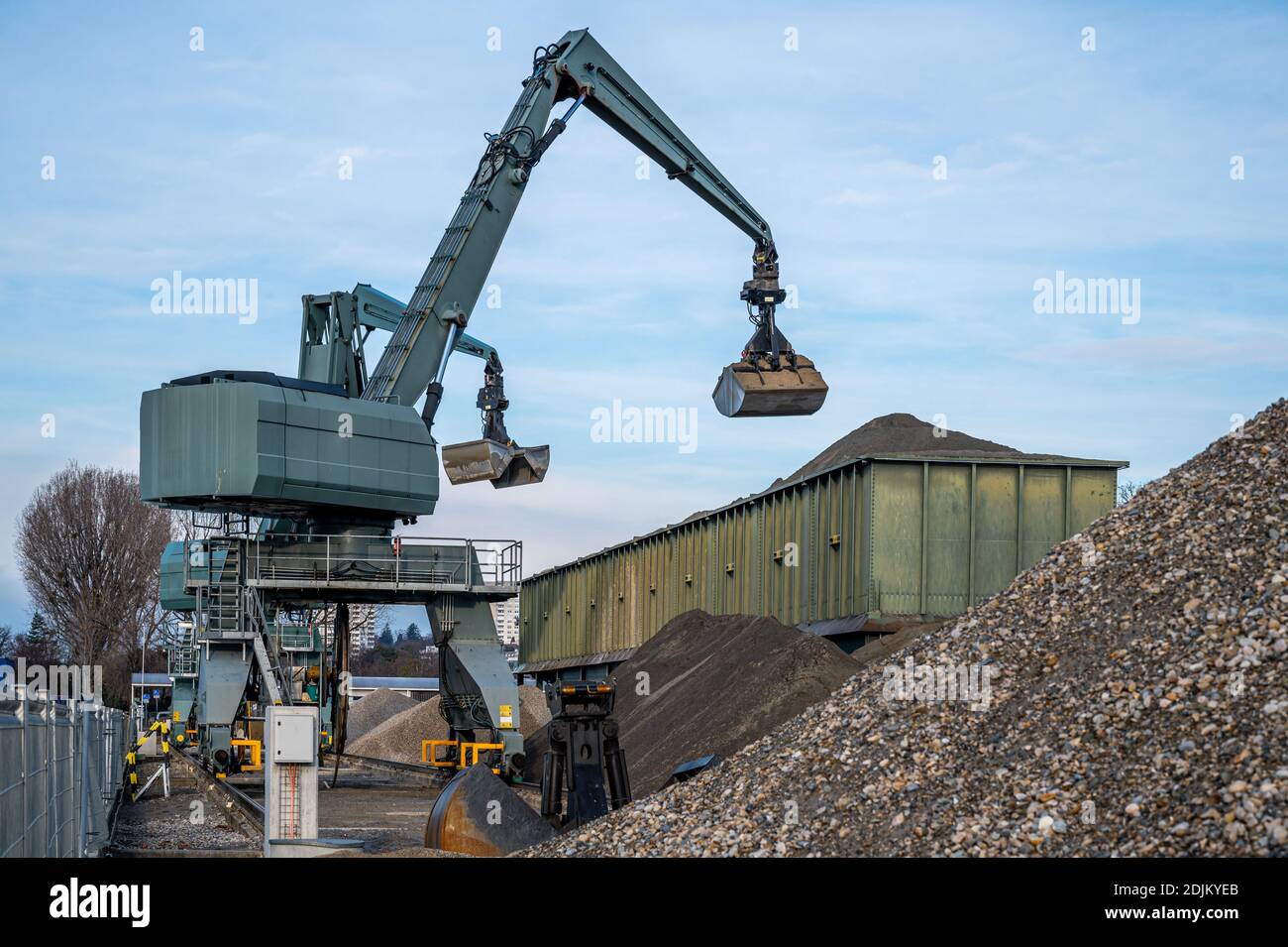 Big excavator working by handling pebbles from the pile of stones to ...