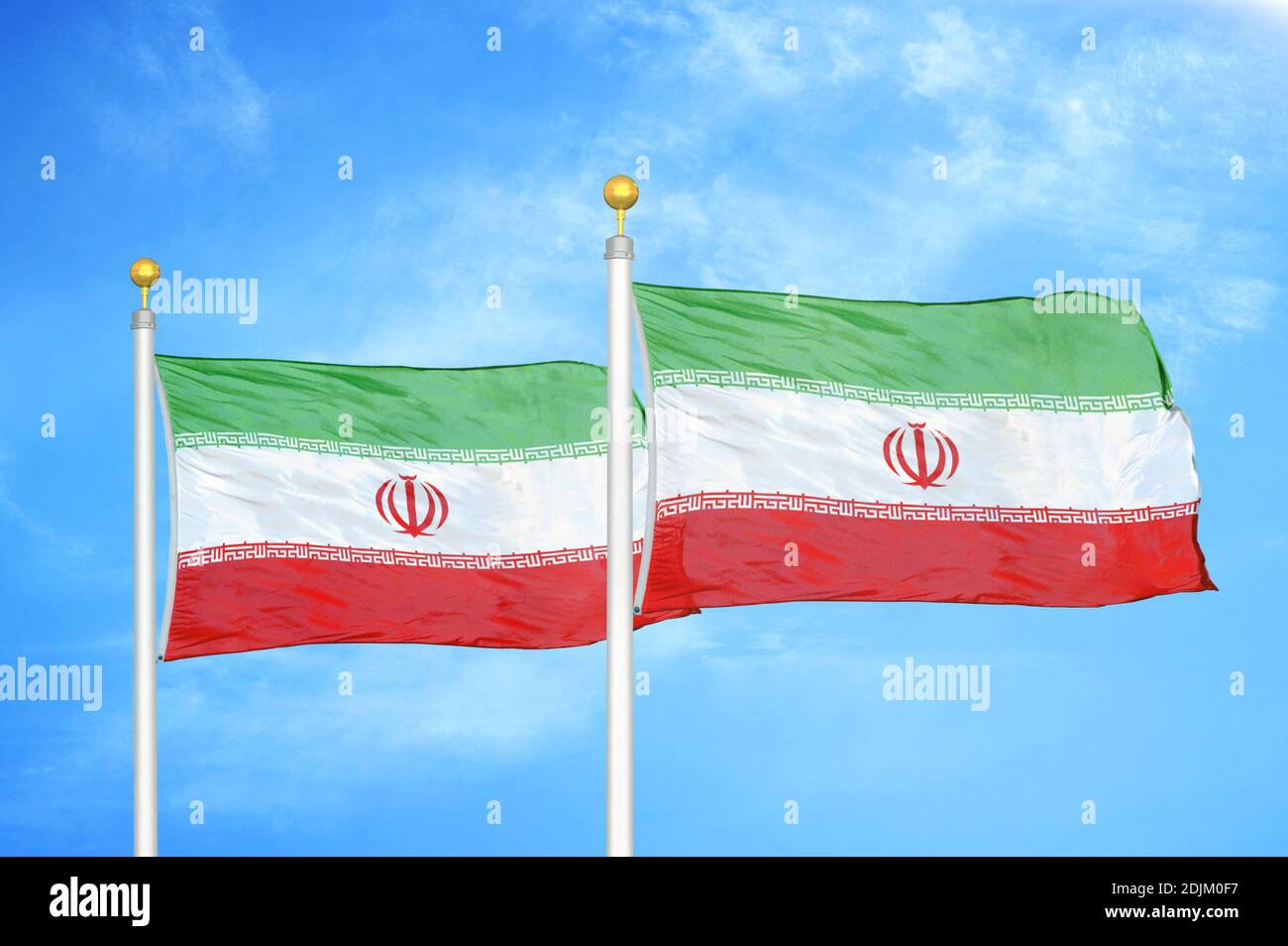 Iran two flags on flagpoles and blue cloudy sky Stock Photo - Alamy