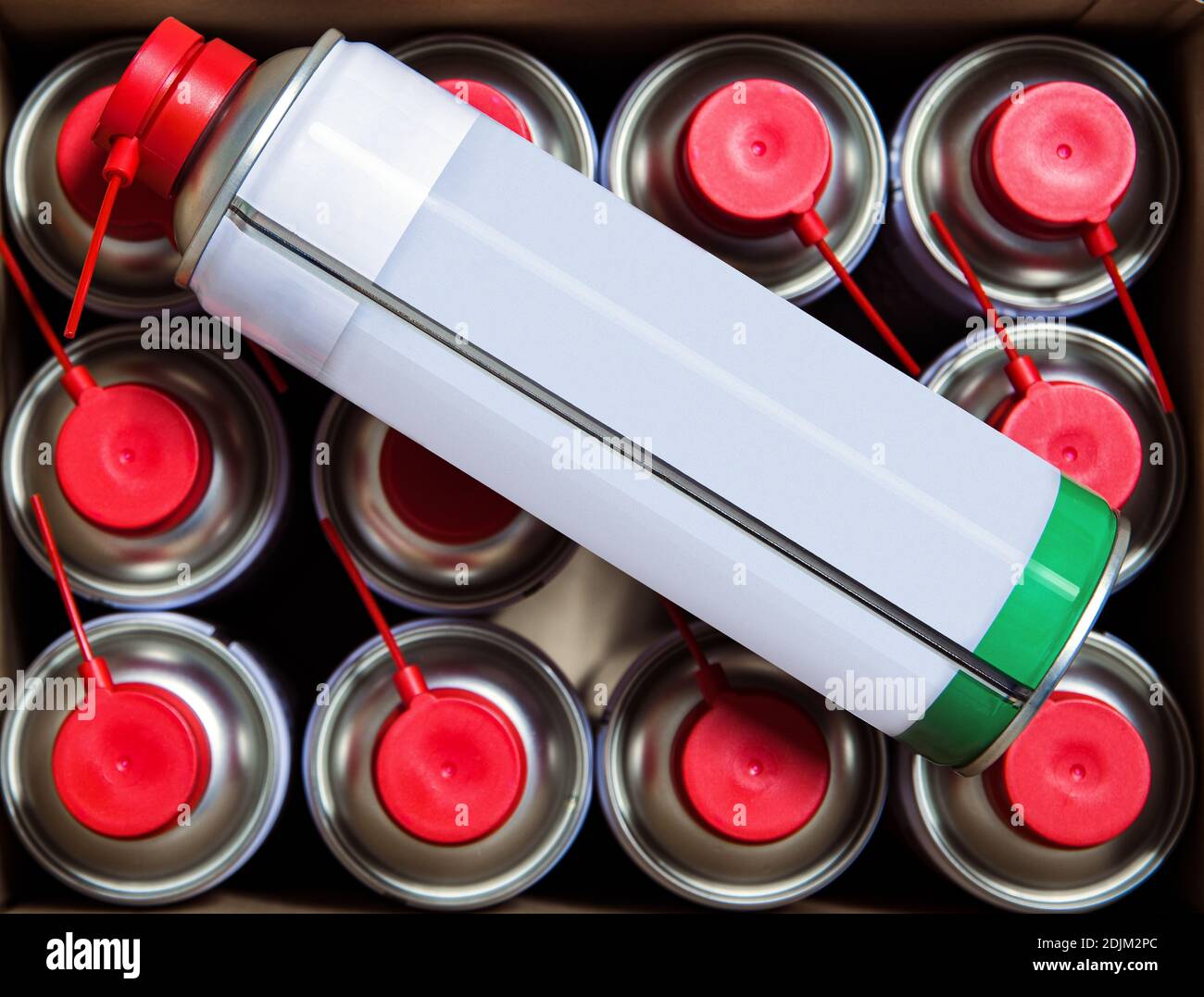 spray can on multiple cans in a box with caps on the spray at shallow ...