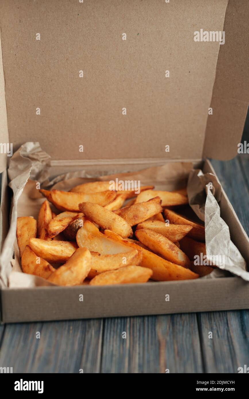 Slices of fried potatoes in box for food delivery. Delivered take away ...