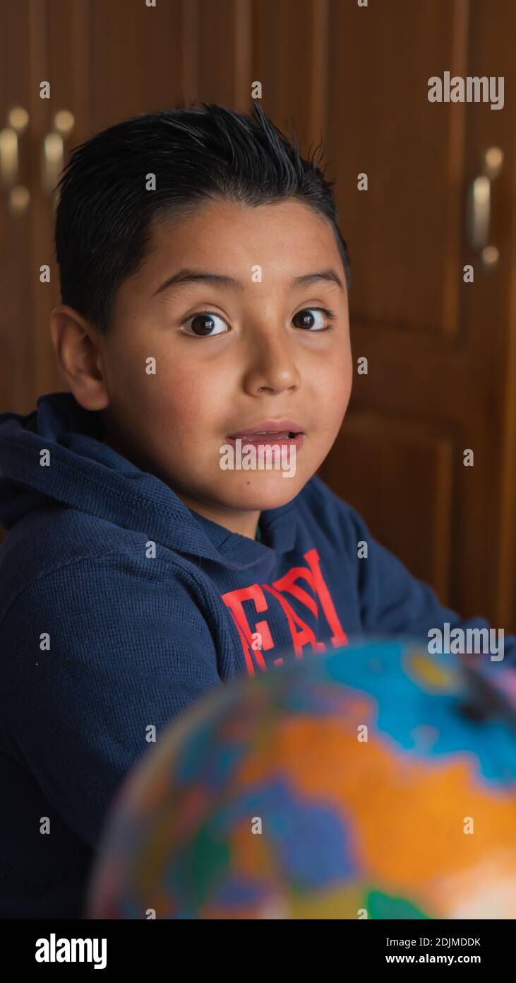 A vertical shot of a Hispanic child studying from home Stock Photo - Alamy