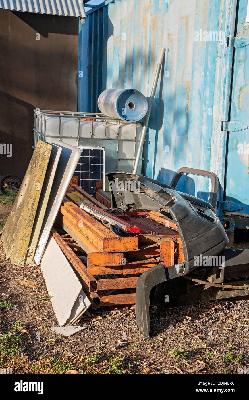 A pile of timber and other junk thrown against a container in a rural ...