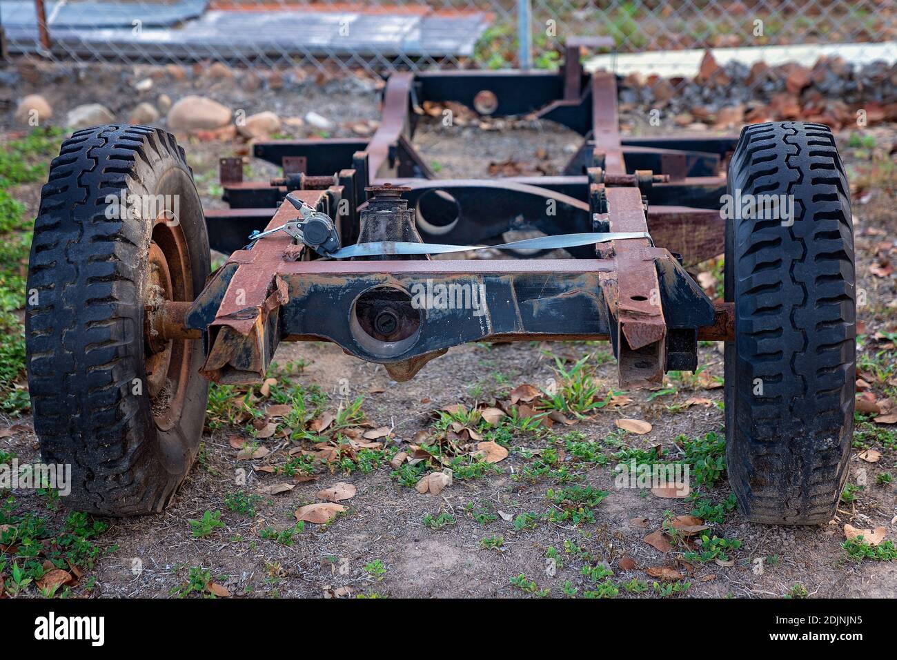An old car chassis discarded in a rural backyard Stock Photo - Alamy