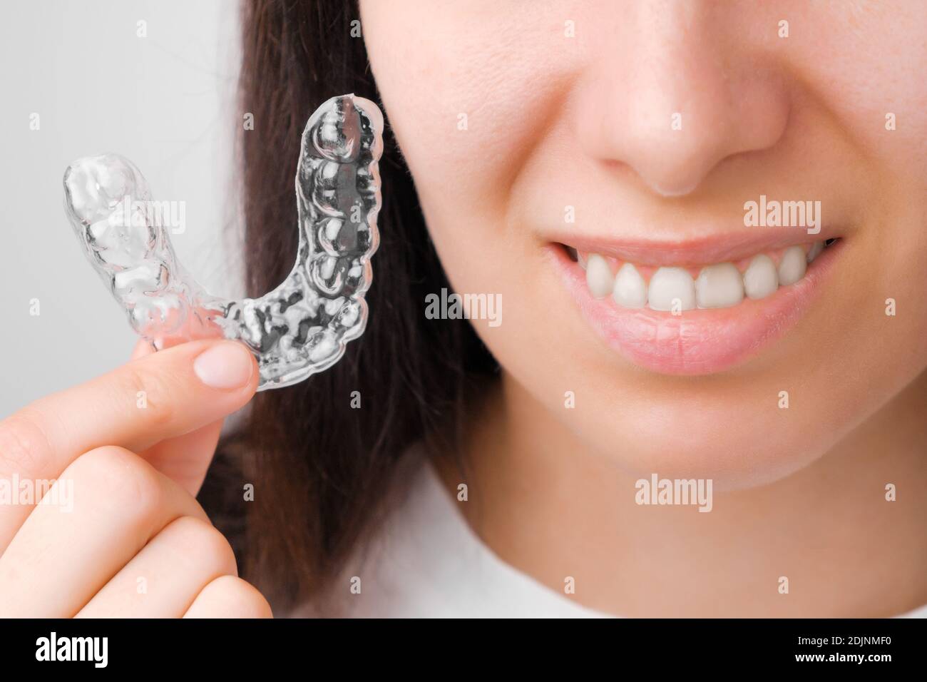 Close up woman holding a transparent removable braces for perfect smile ...