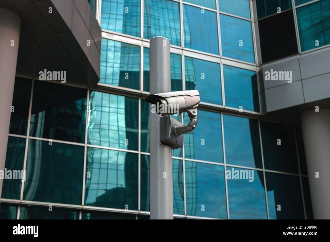External surveillance camera against glass building facade Stock Photo ...