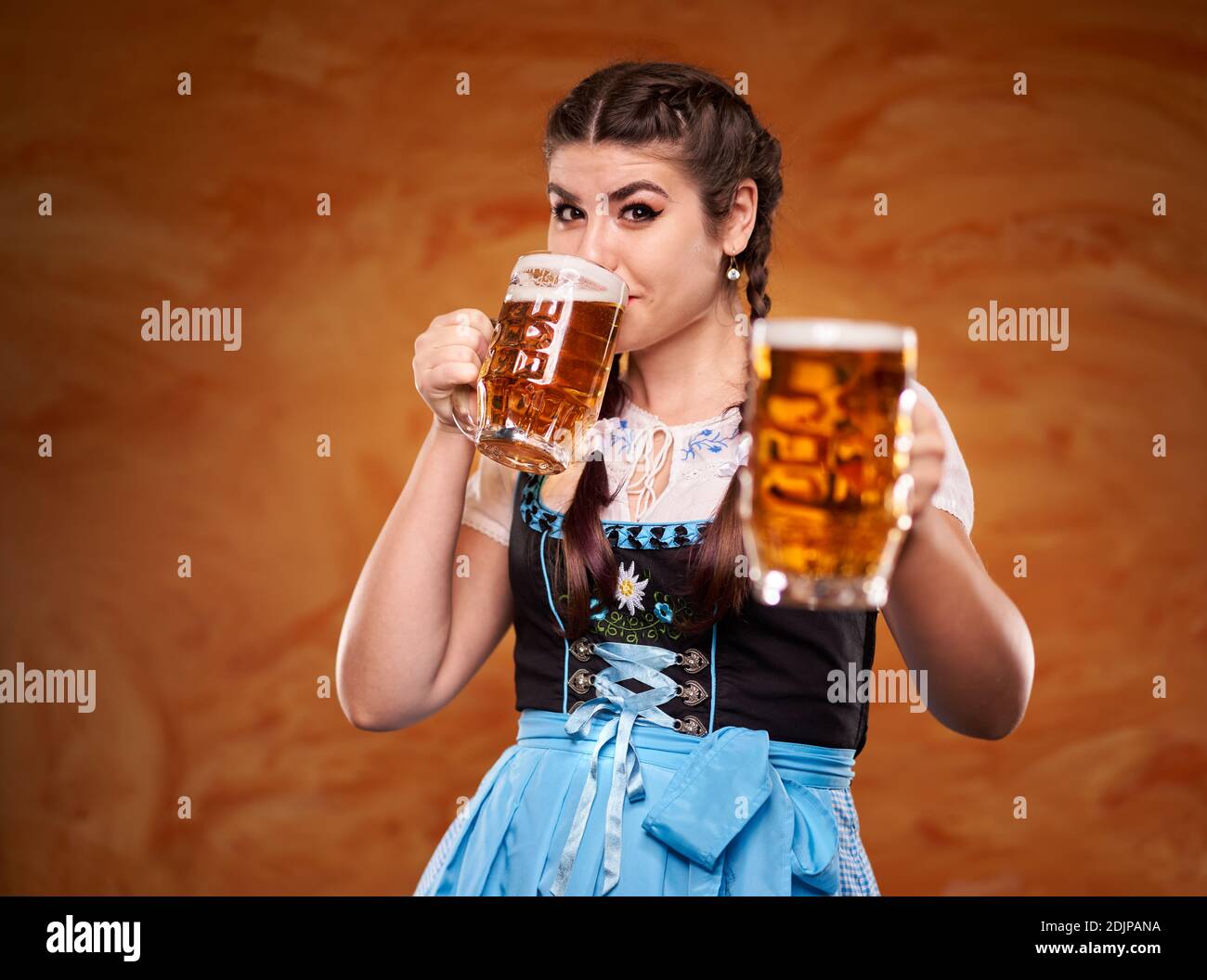 German girl in traditional costume drinking large pints of lager Stock ...