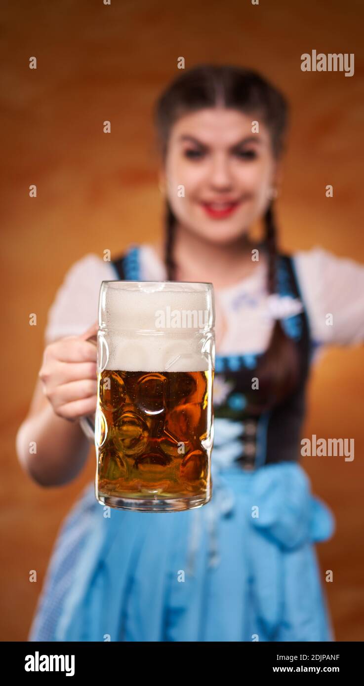 German girl in traditional costume serving large pints of lager Stock ...