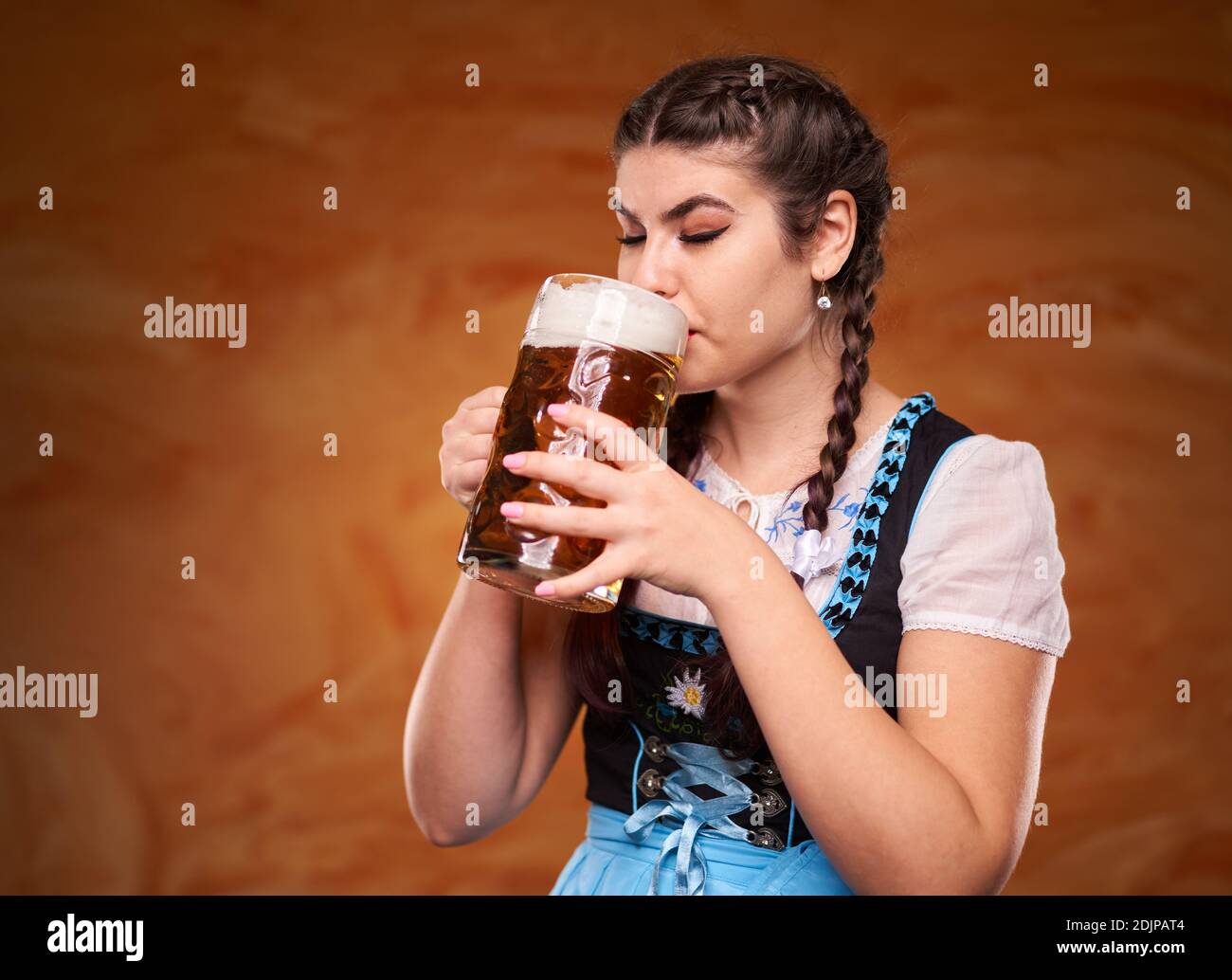 German girl in traditional costume drinking large pints of lager Stock ...