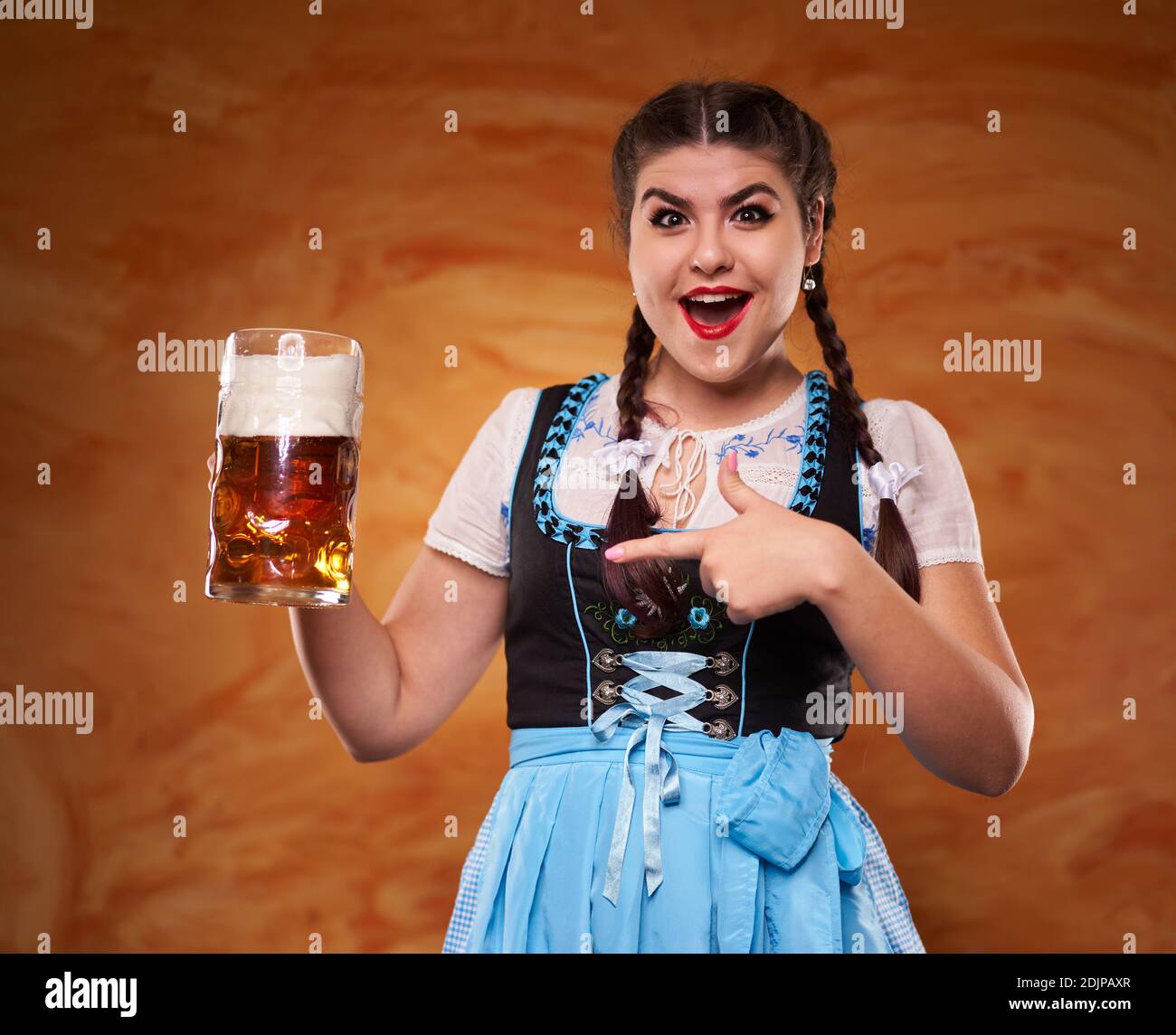 German girl in traditional costume serving large pints of lager Stock ...