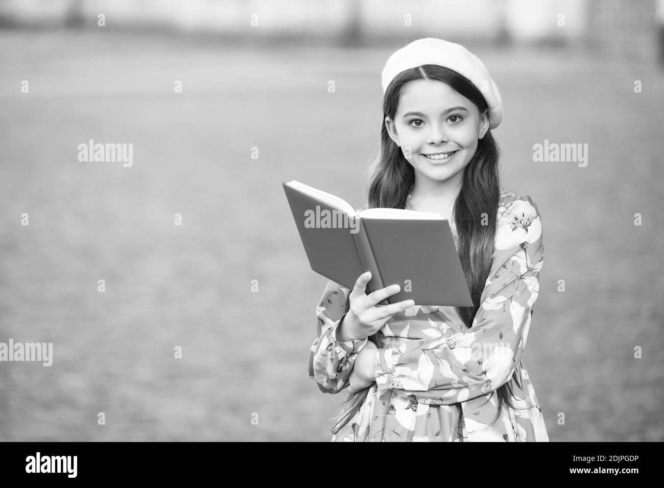 Traveling library. Happy girl hold library book outdoors. Little child ...