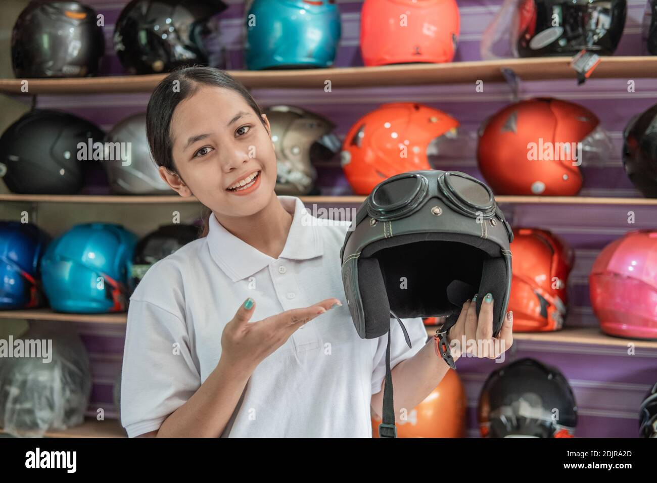 woman shop assistant smiles with hand gestures to offer something while ...