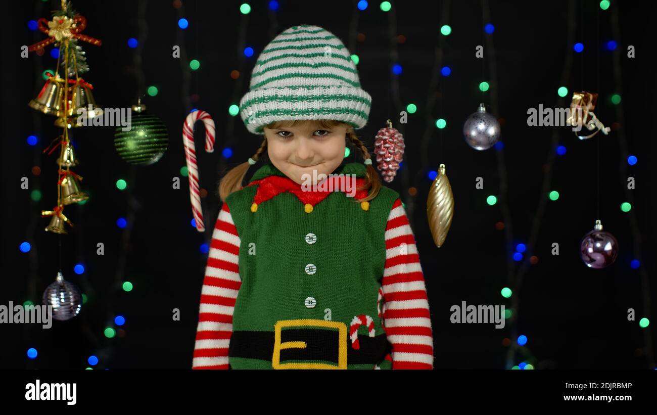 Displesed funny kid girl in elf Santa helper costume having spoiled ...