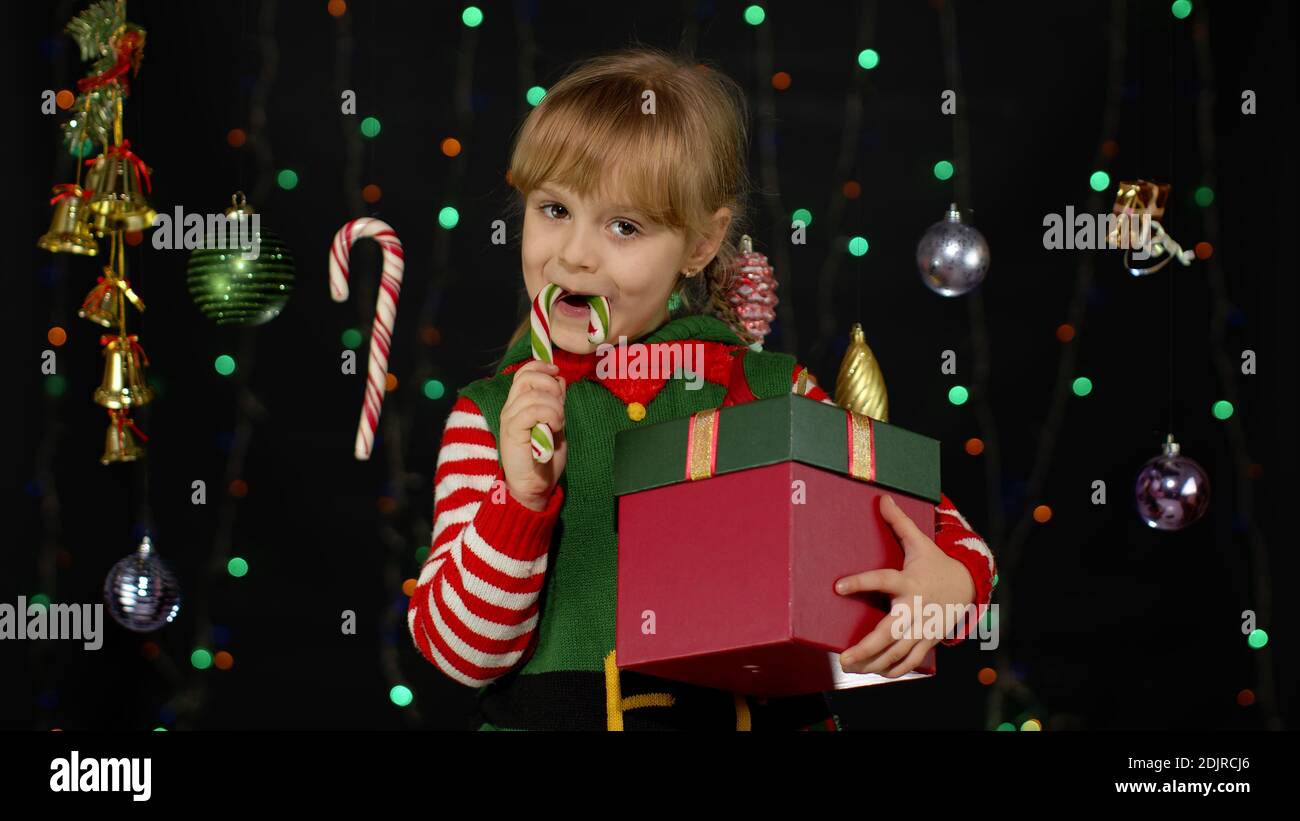 Child with surprise gift box enjoying caramel sweets. Kid girl in ...