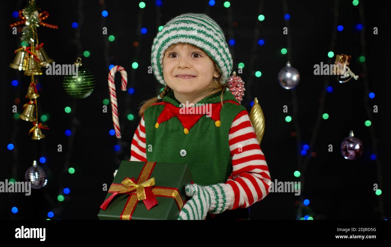 Kid child in Christmas elf Santa Claus helper costume holding present ...