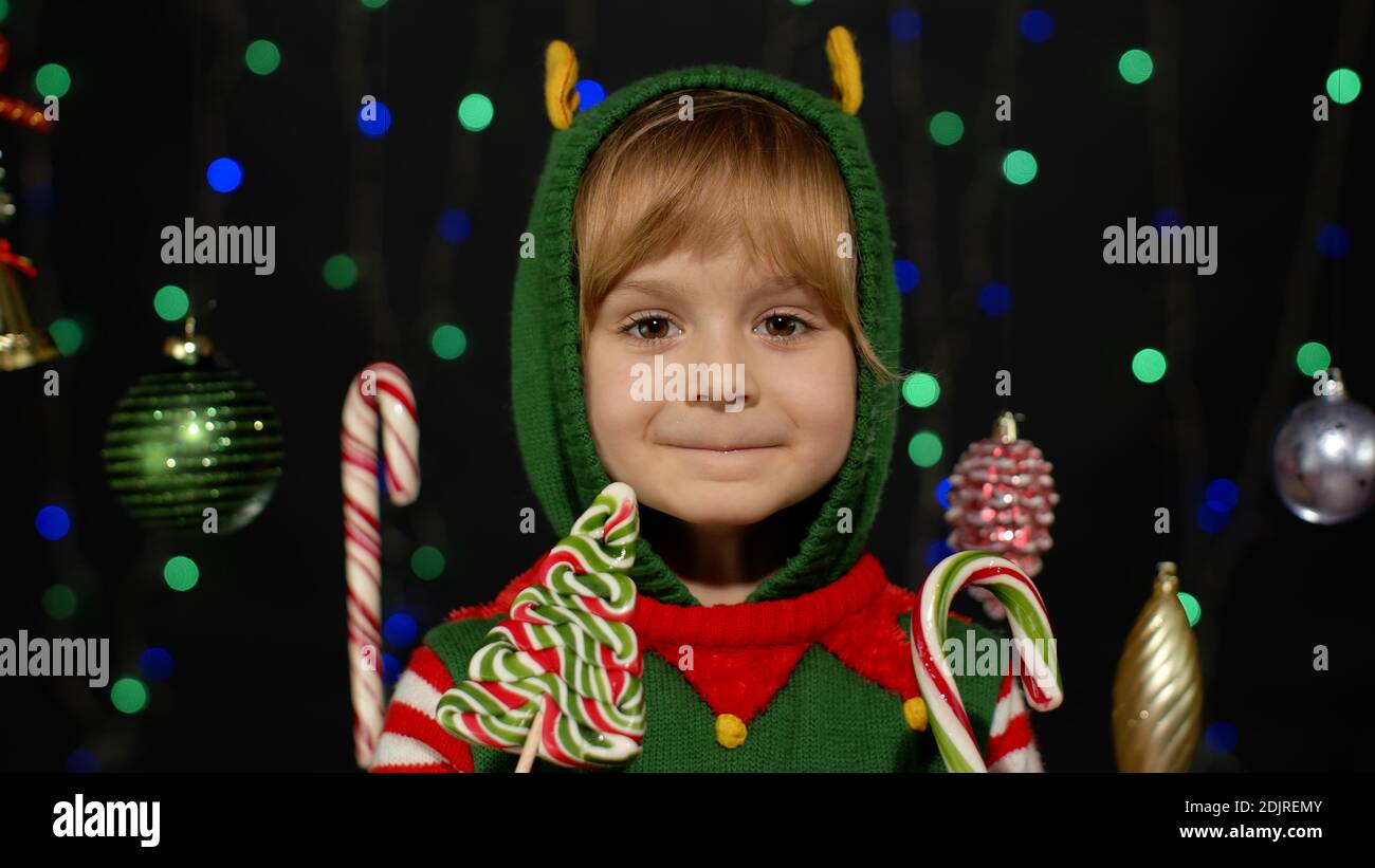 Blonde kid girl in Christmas elf Santa Claus helper costume with ...