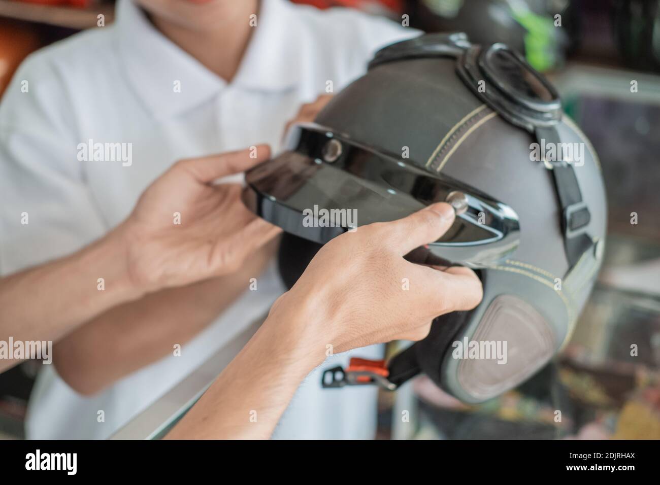 female and male hands holding helmet when standing near display window ...