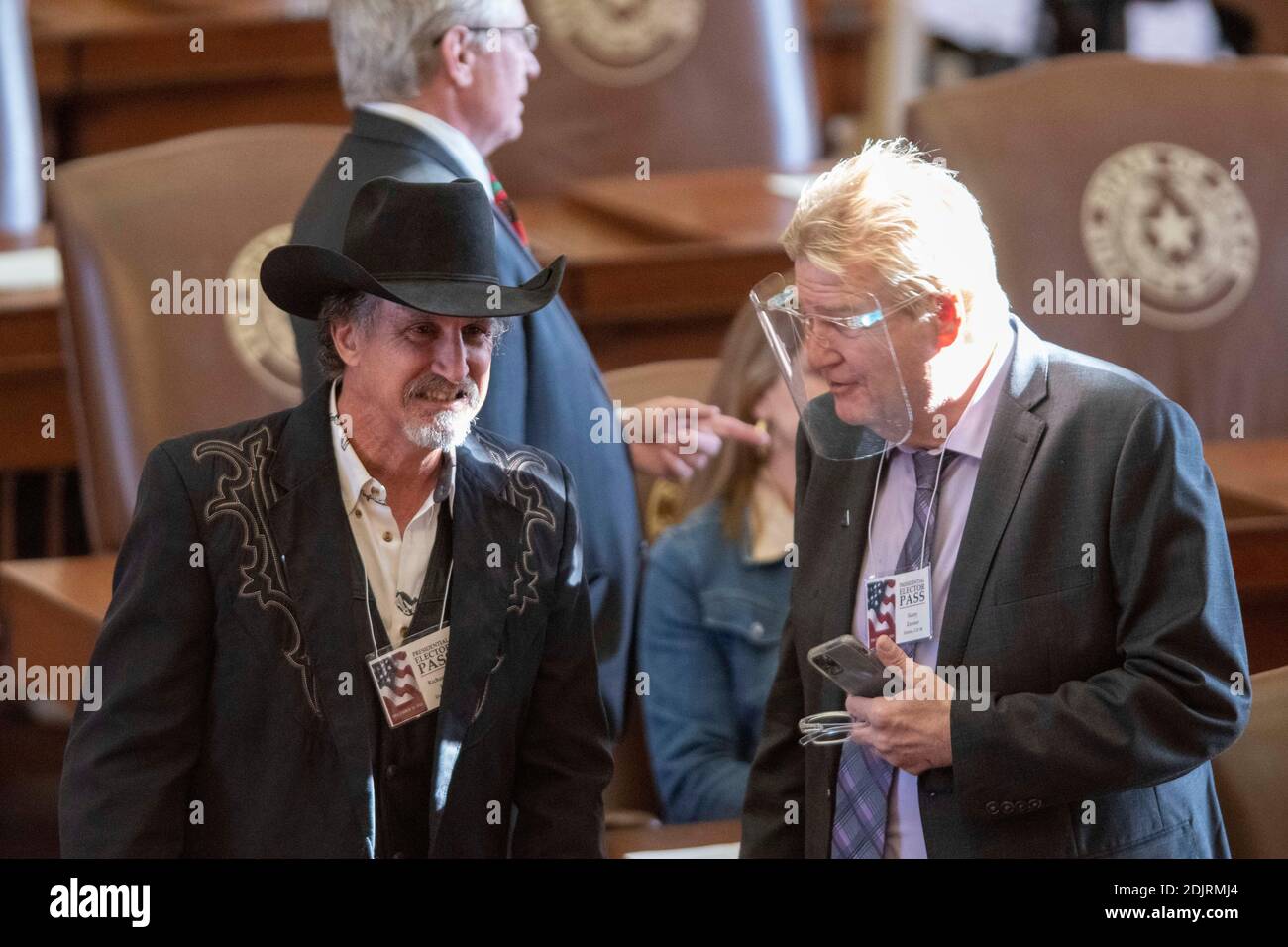 Austin, Texas, USA. 14th Dec, 2020. Elector Richard Hall (l) wears no ...