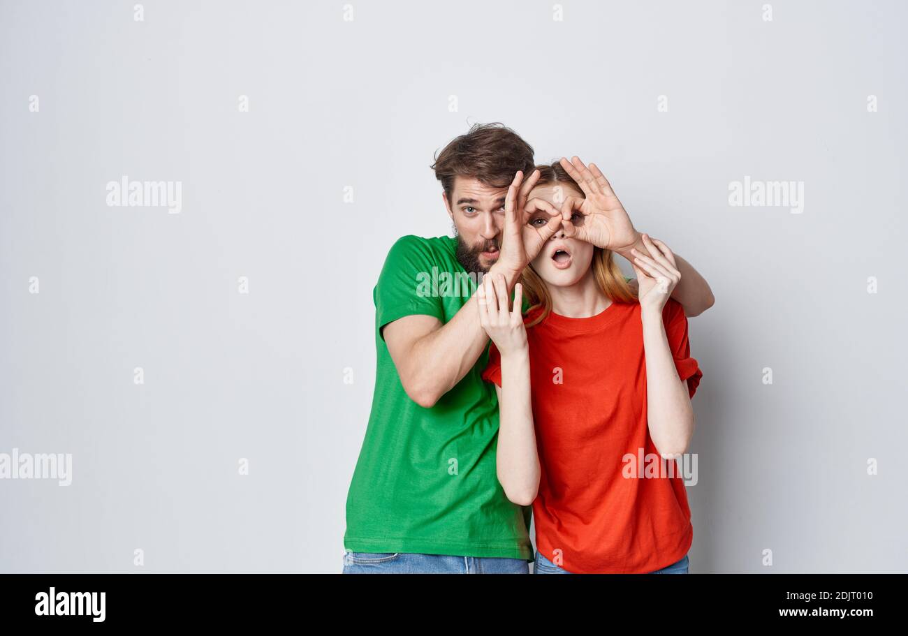 funny man and woman in multicolored t-shirts emotions hand gestures ...