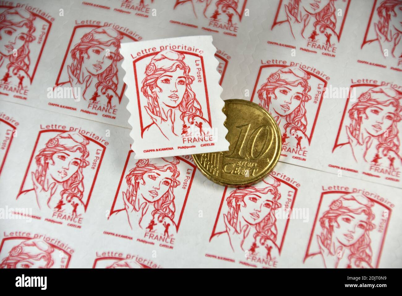In this photo illustration a post stamp and a 10 euro cent coin seen on ...