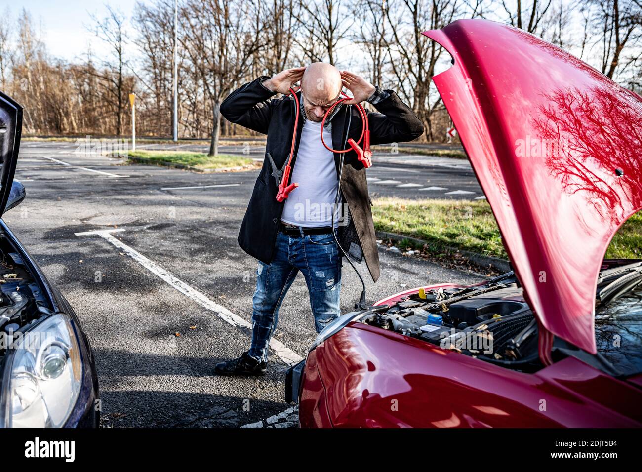 Furious driver trying to start broken car with jumper cables Stock ...