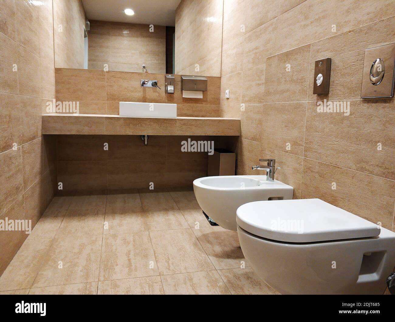 Stylish dressing room with bidet. Beige tiles Stock Photo - Alamy