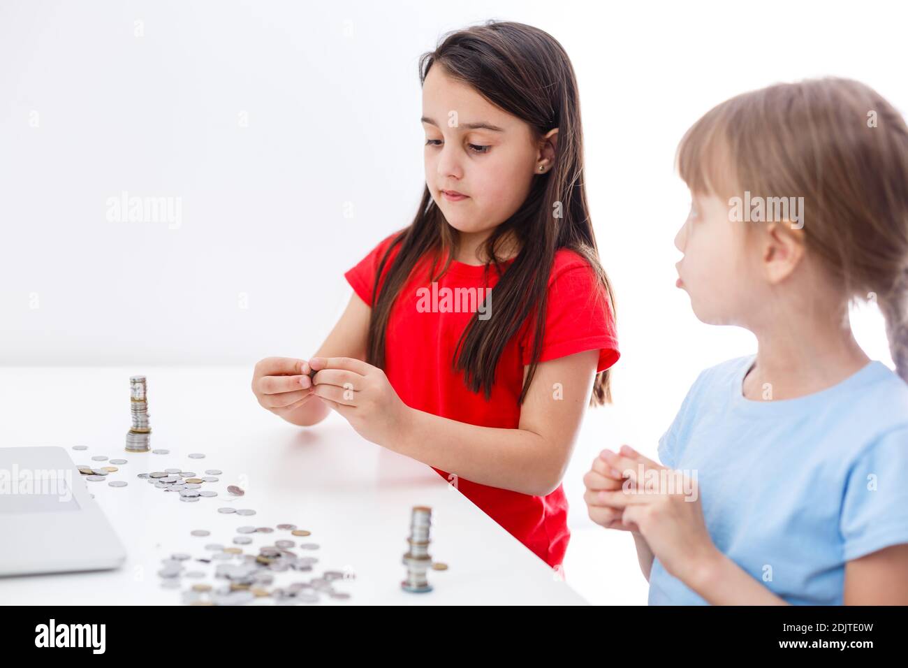 Two kids counting coins together Stock Photo - Alamy