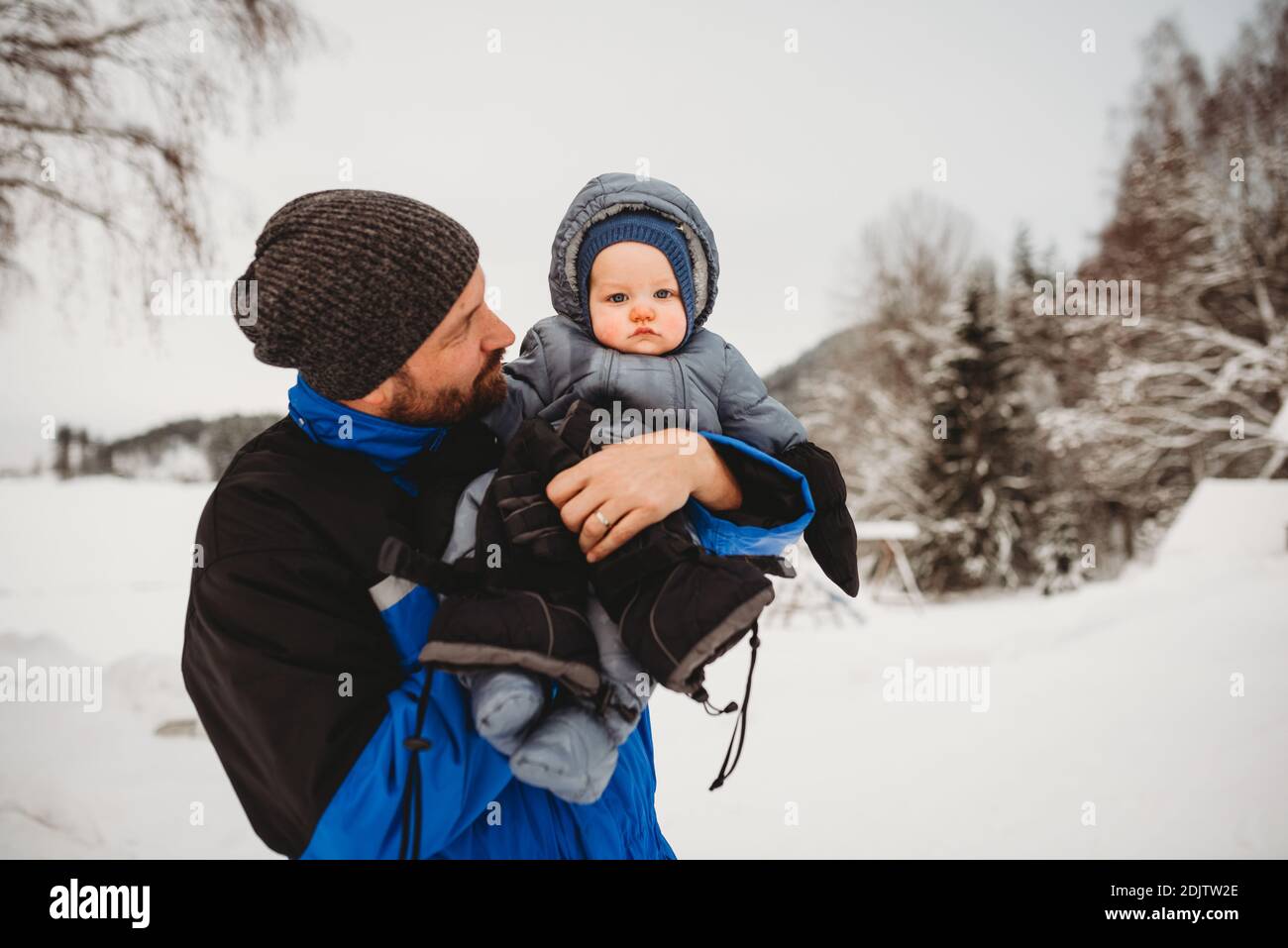 Dad and baby on cold cloudy day in the snow in mountain forest Stock ...