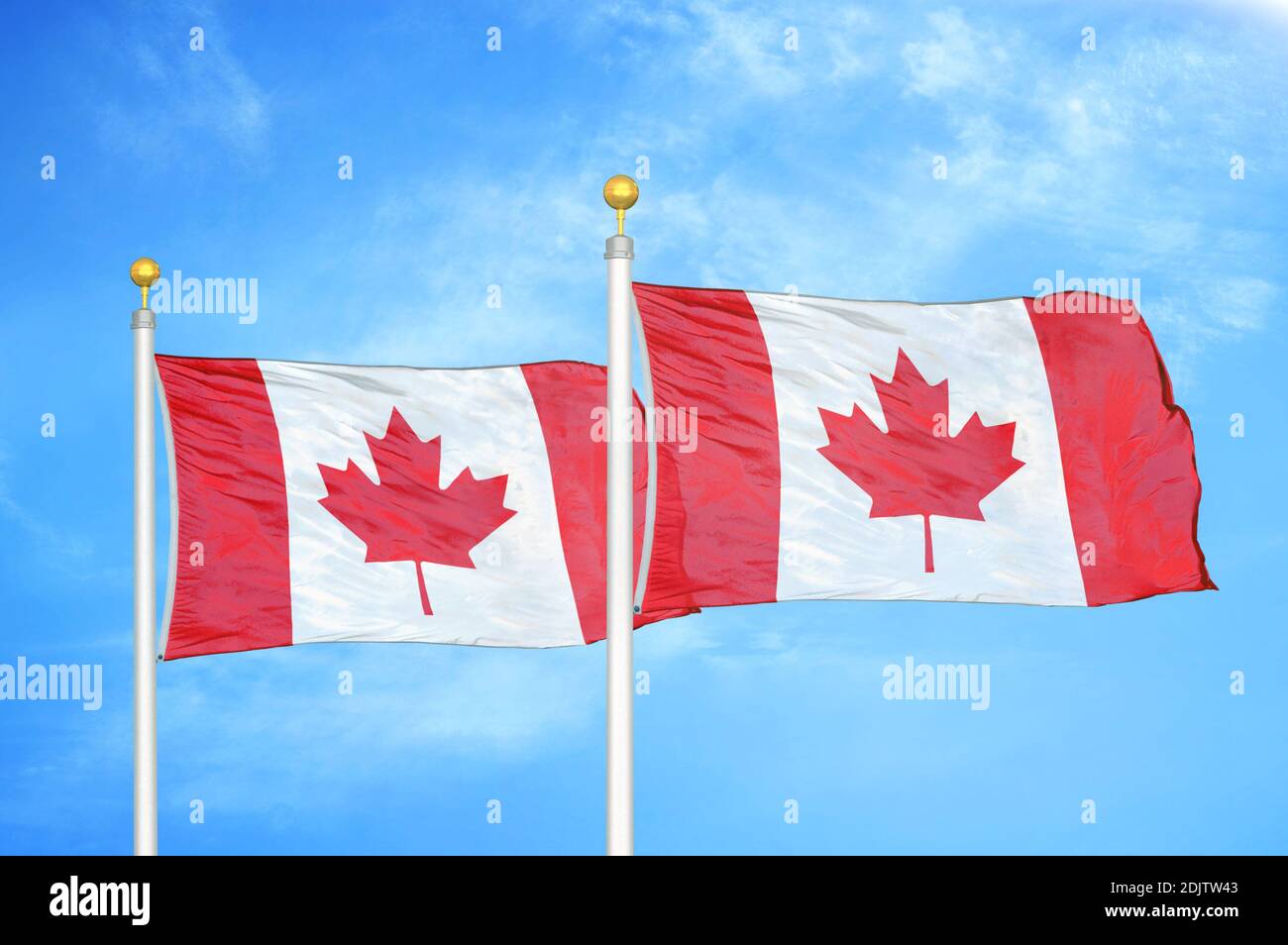 Canada two flags on flagpoles and blue cloudy sky Stock Photo - Alamy