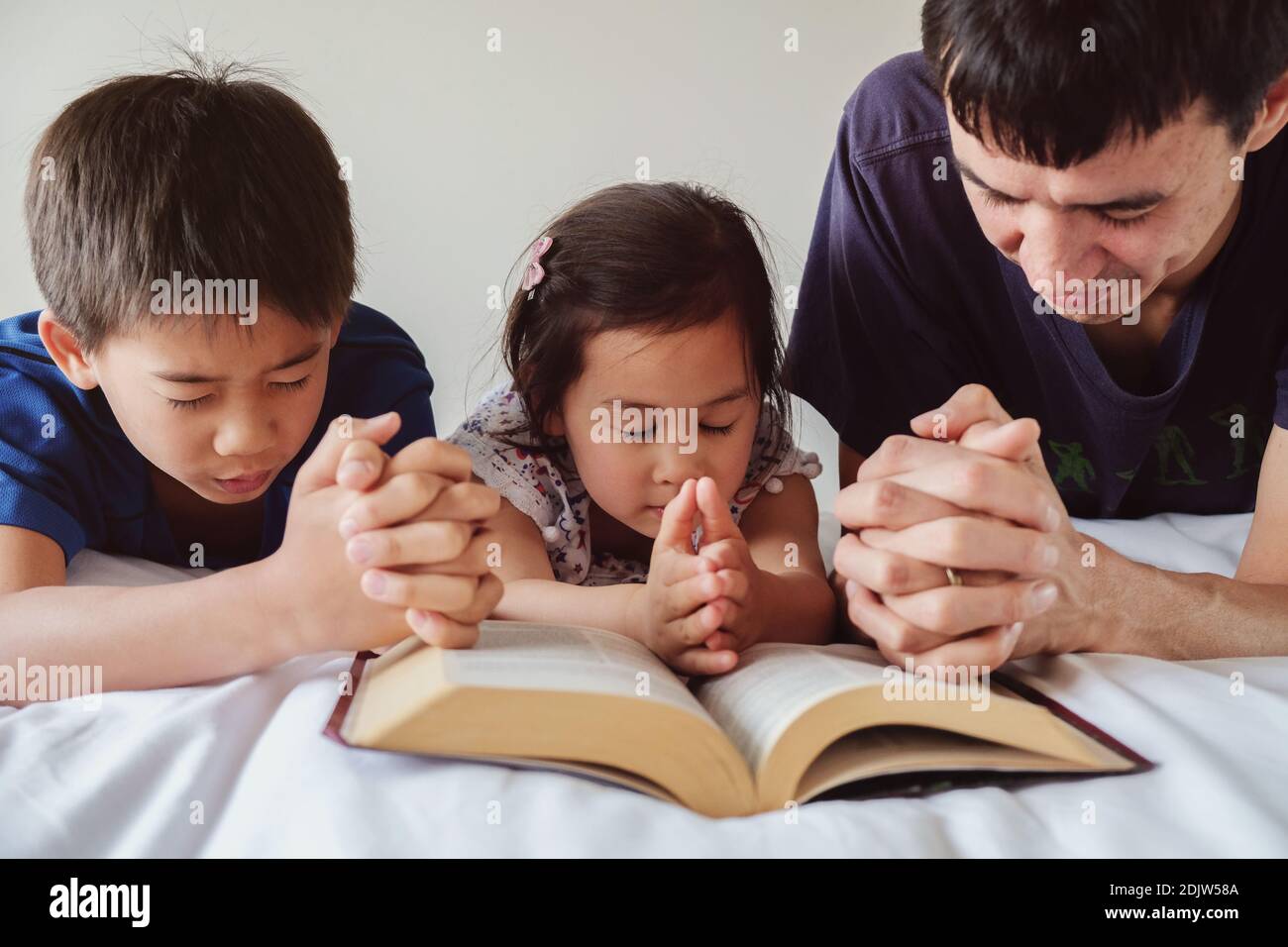 Family praying bed hi-res stock photography and images - Alamy