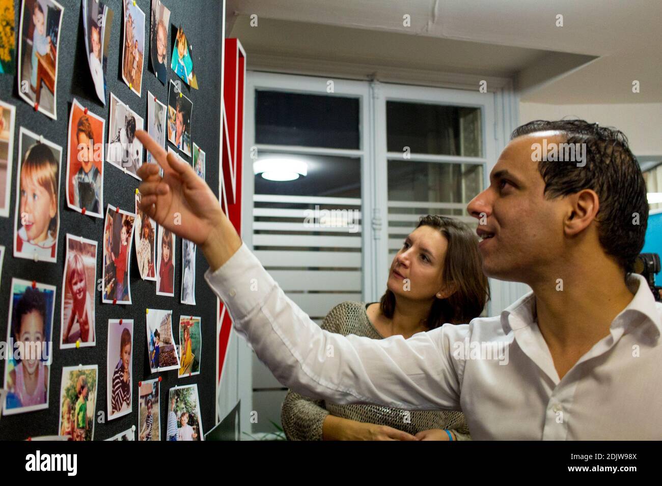 Members of her campaign commitee look at some pictures in a wall of a ...
