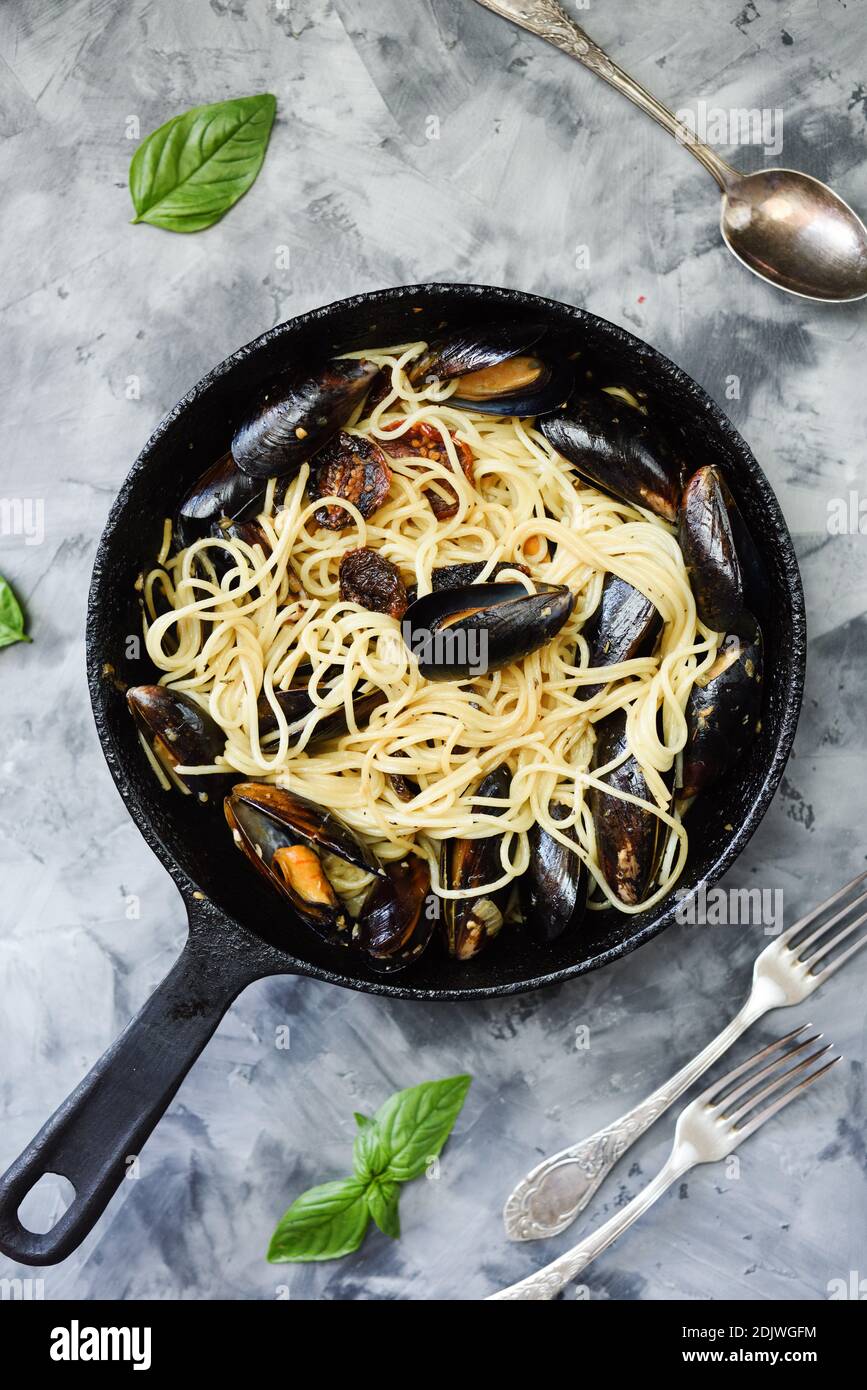 Seafood pasta. Spaghetti with mussels in shells in cast iron pan on ...