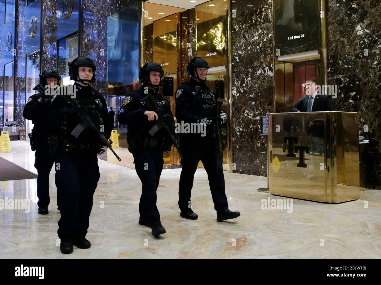 Armed NYPD police officers walk through the lobby of Trump Tower on ...